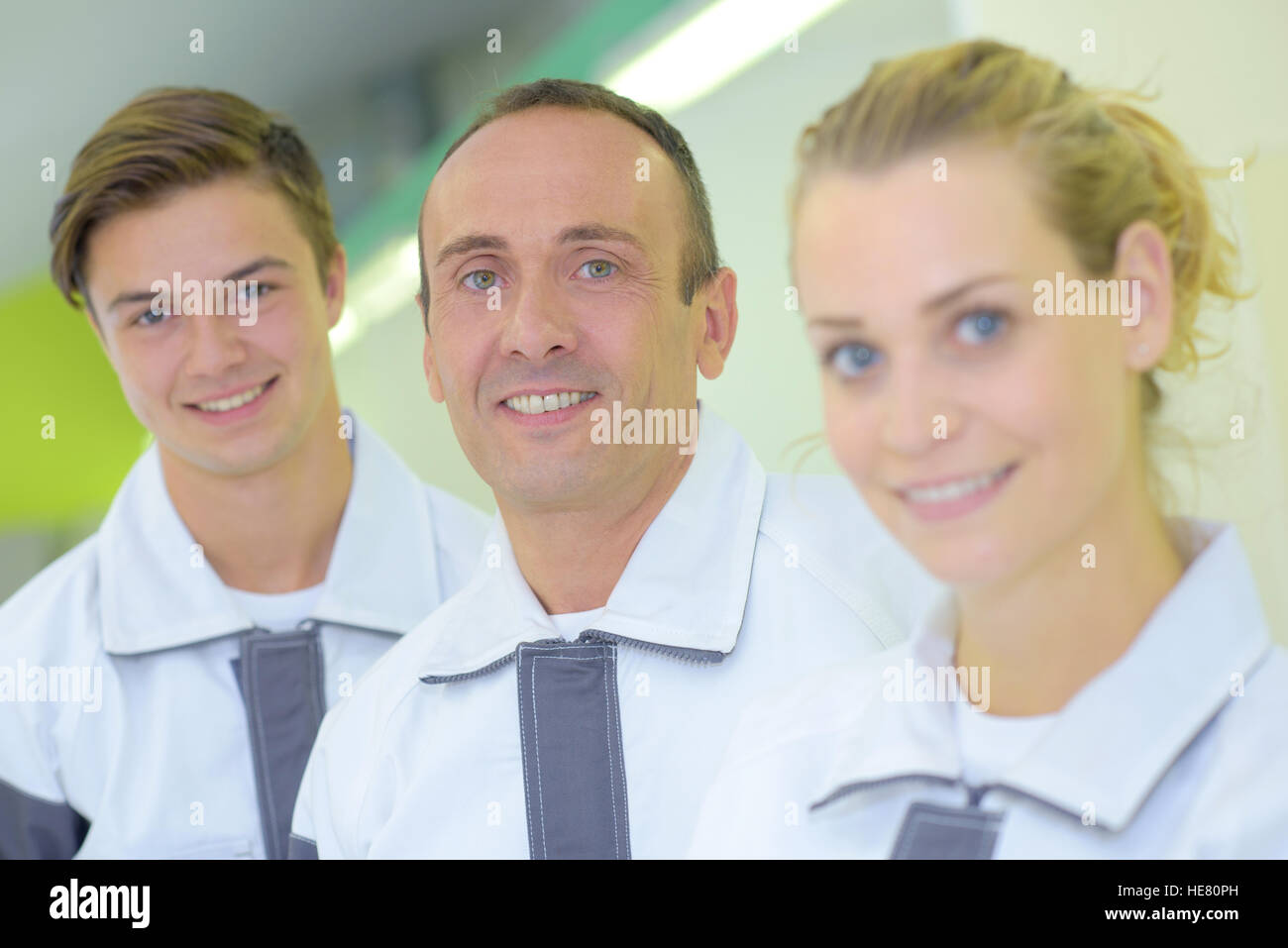 Portrait of three workers in matching uniforms Stock Photo - Alamy