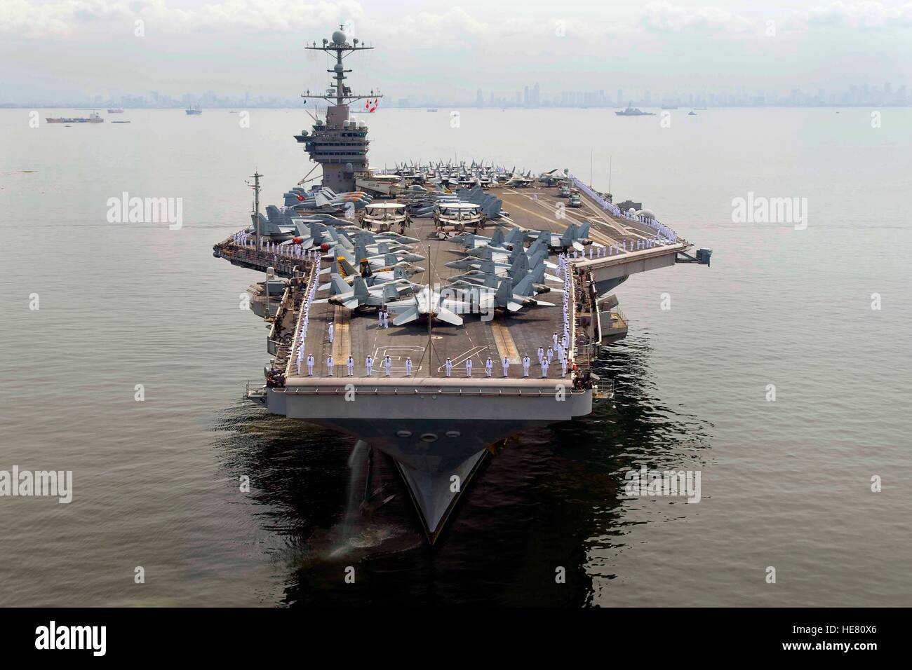 U.S. sailors man the rails aboard the USN Nimitz-class aircraft carrier ...
