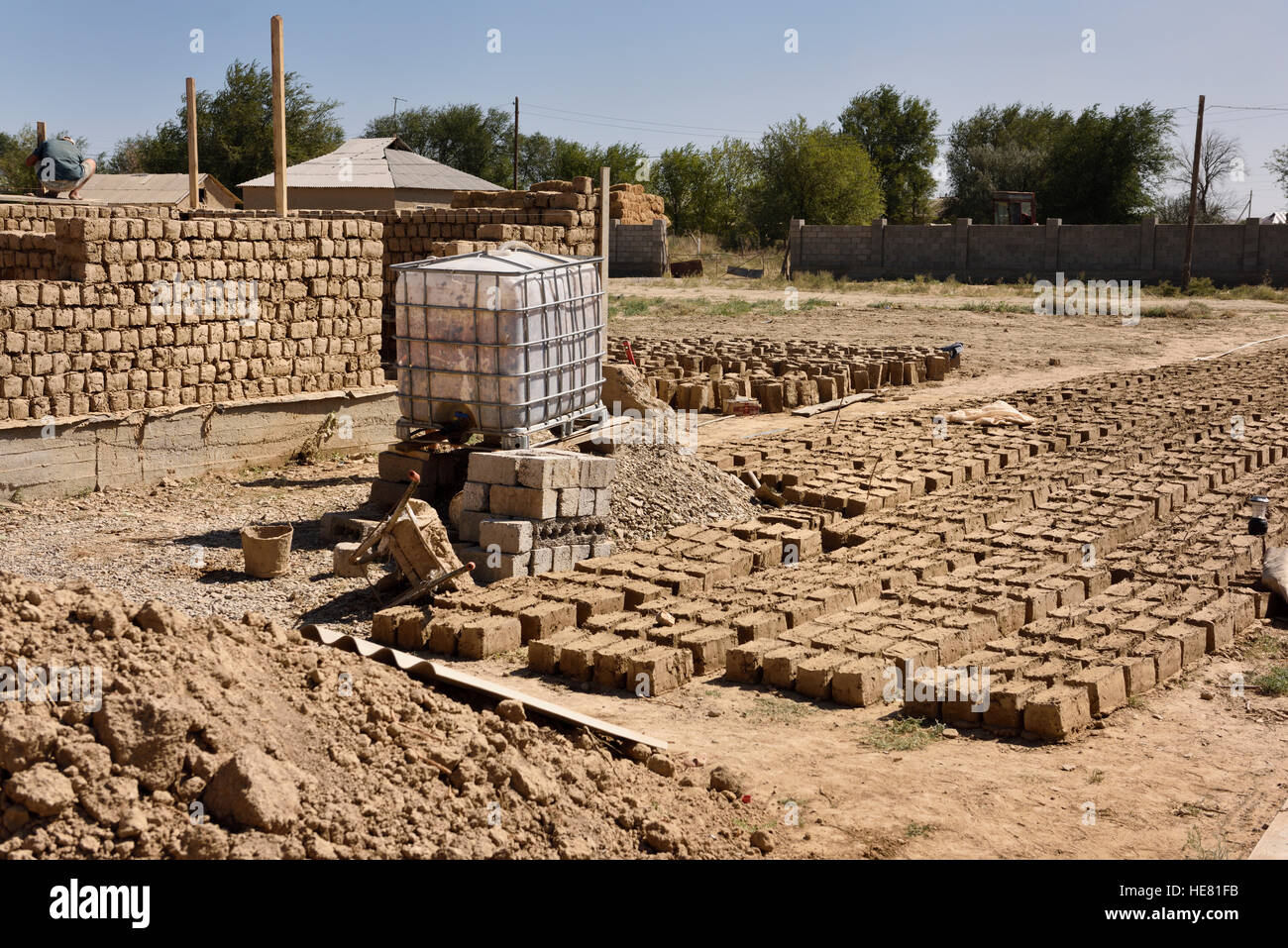 Mud bricks sun drying at residential construction site development near ...