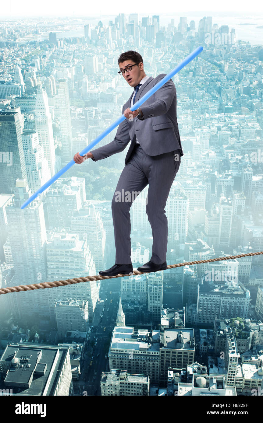 Businessman doing tightrope walking in risk concept Stock Photo - Alamy