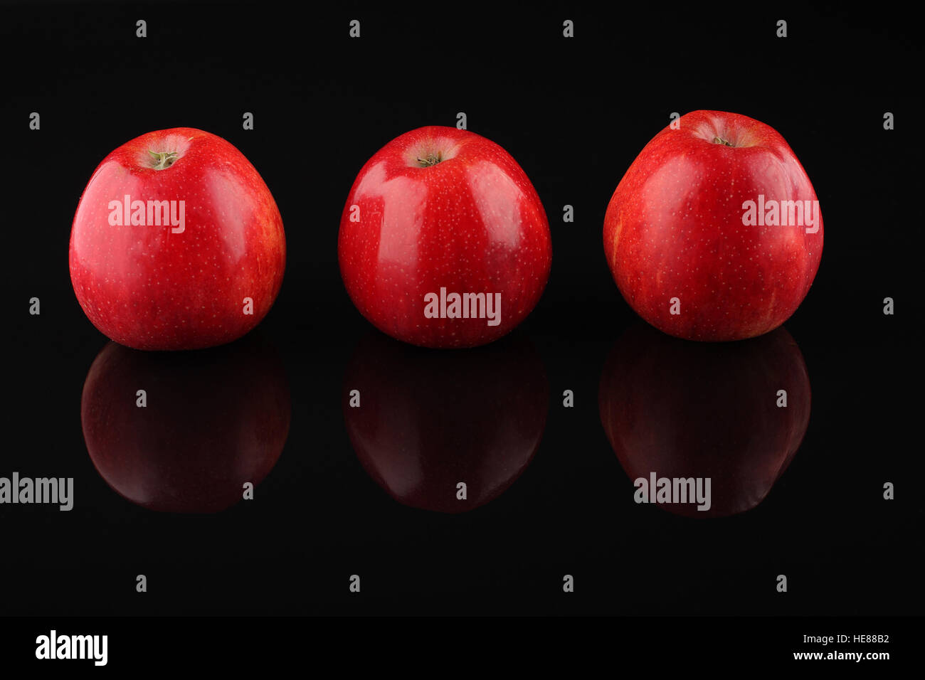 Three red apples isolated on black acrylic sheet with reflection Stock ...