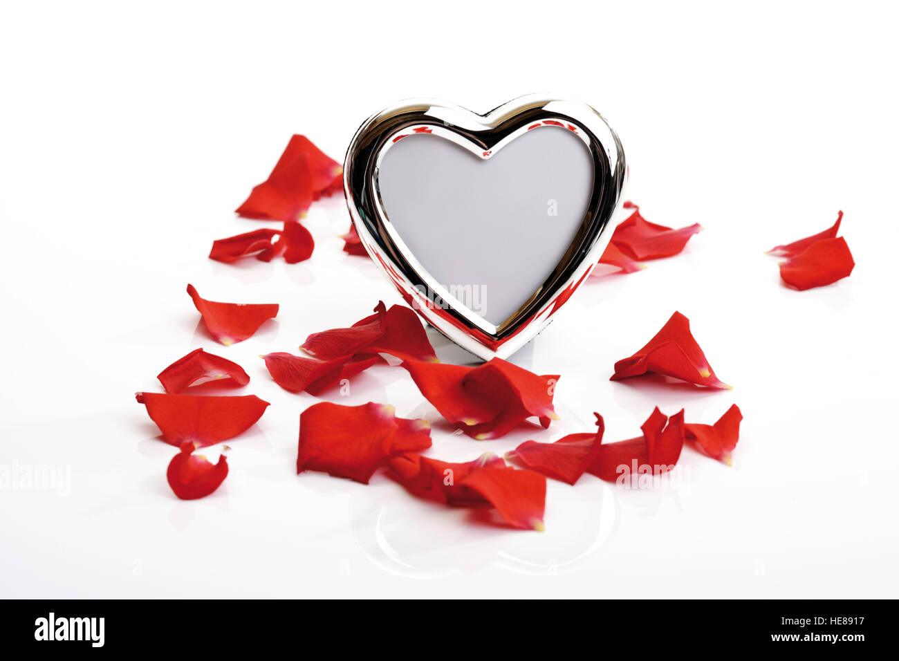 Heart-shaped picture frame and red rose petals Stock Photo - Alamy