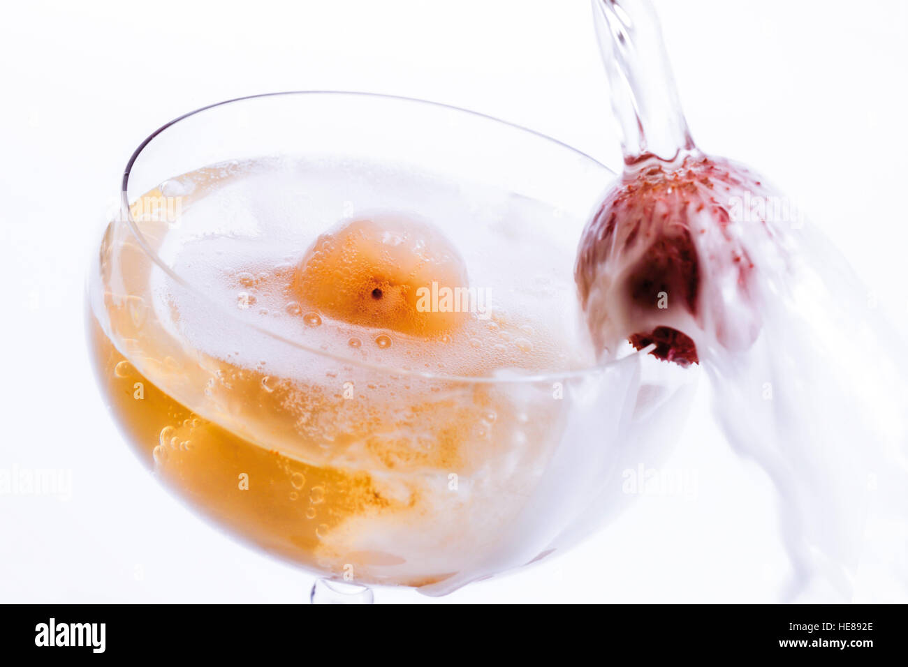 Sparkling wine with lychee fizzing over Stock Photo - Alamy