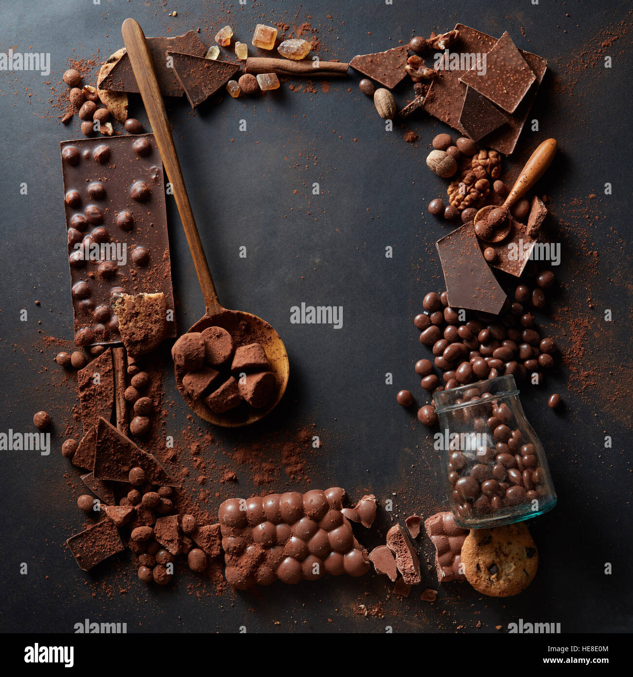 frame of different chocolates and cocoa powder on a dark background ...