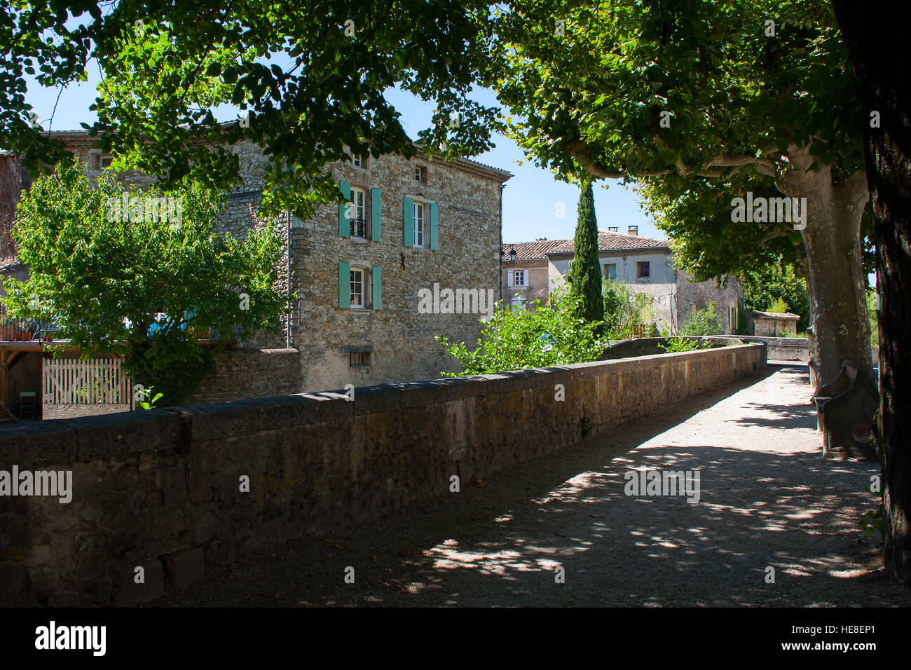 Typical French Villa viewed from the dappled shade of a tree lined ...