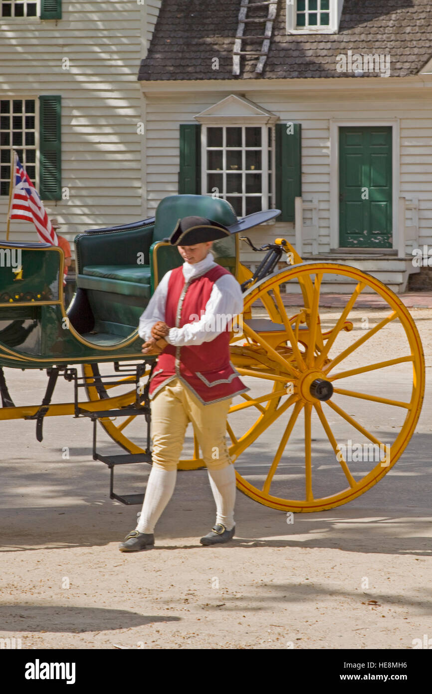 Carriage driver standing by there open horse drawn carriage along the ...
