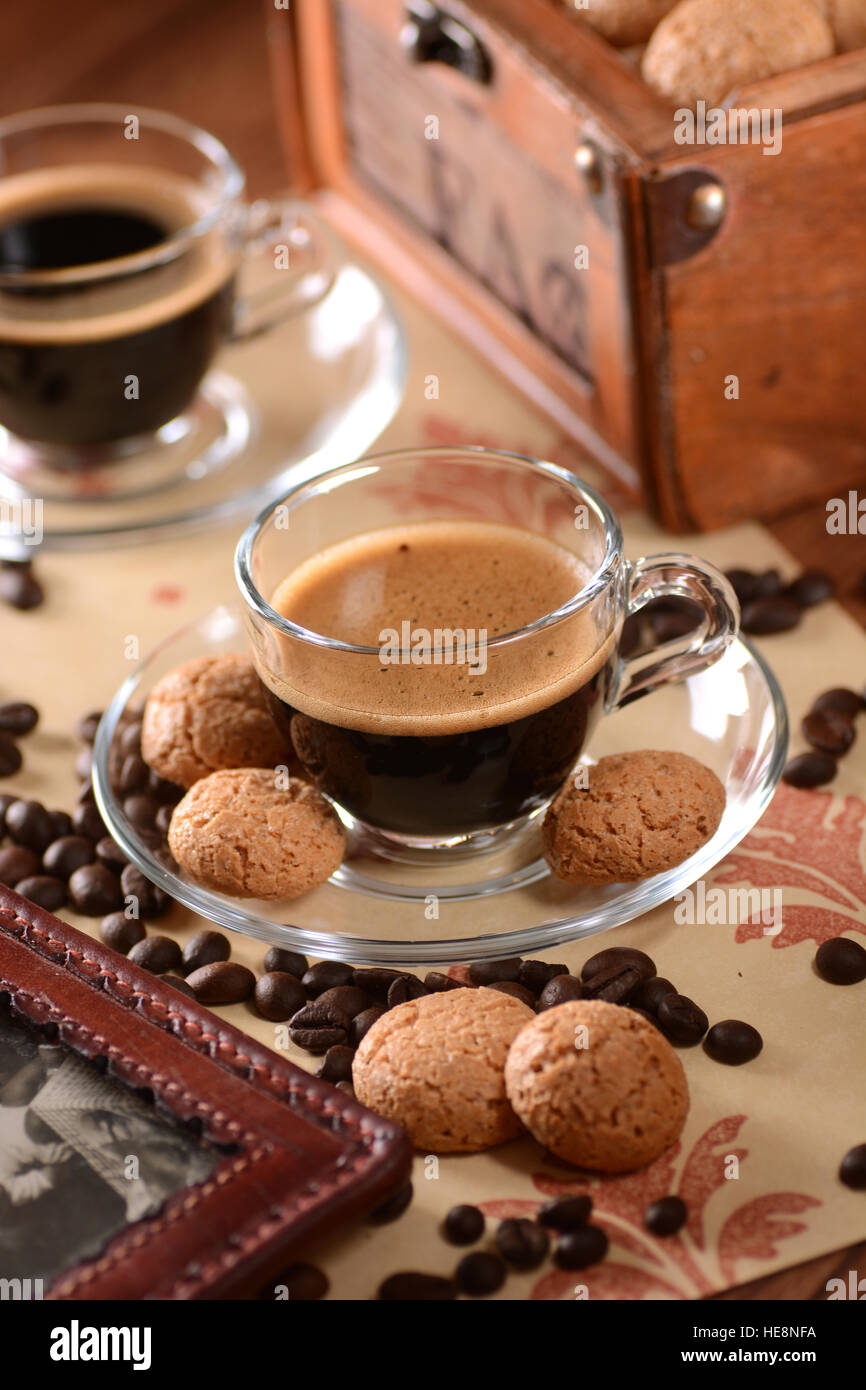 Italian espresso coffee in glass cup with amaretti biscuits around ...