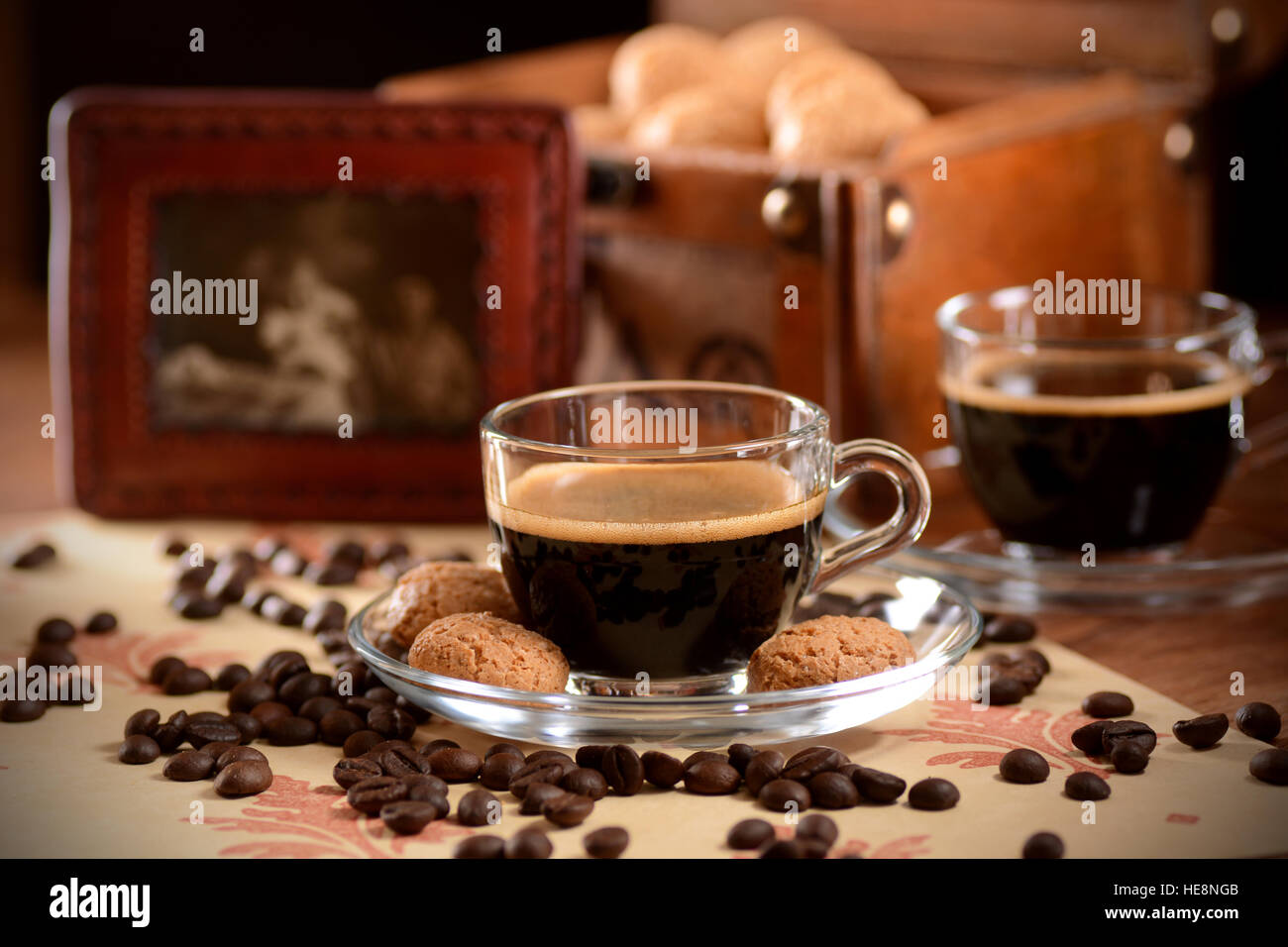 Italian espresso coffee in glass cup with amaretti biscuits around ...