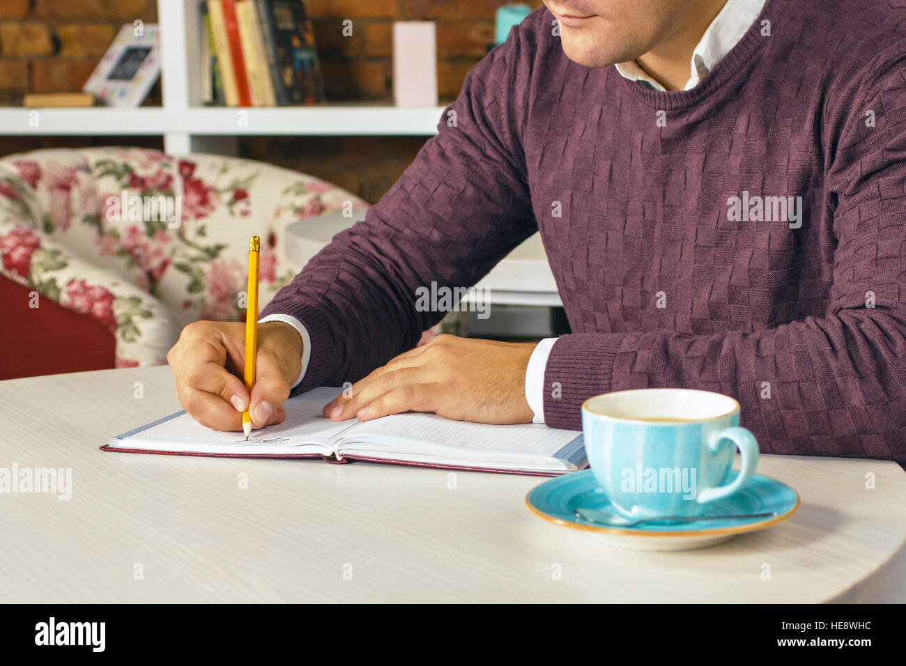 Man holding pencil and writing on a paper in the diary Stock Photo - Alamy