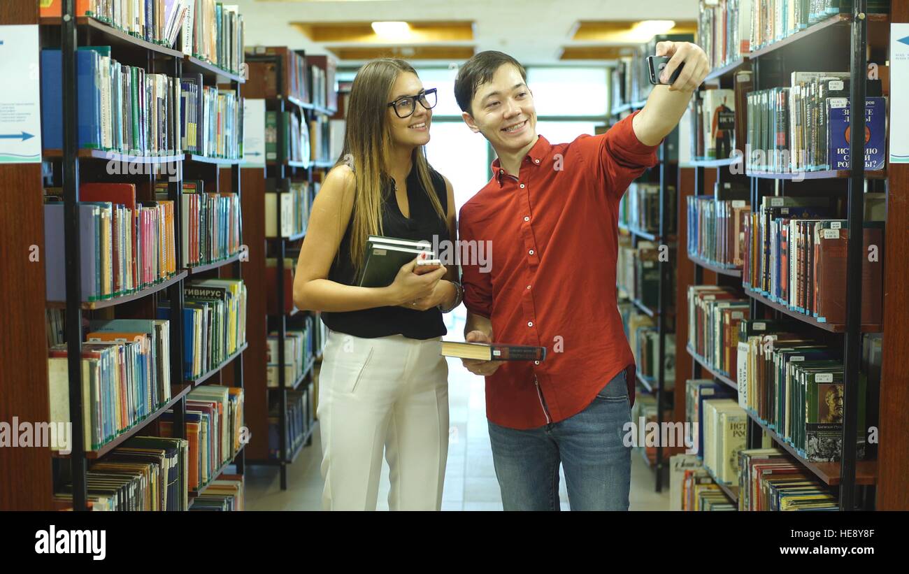 two students taking selfies in the library at the university Stock ...