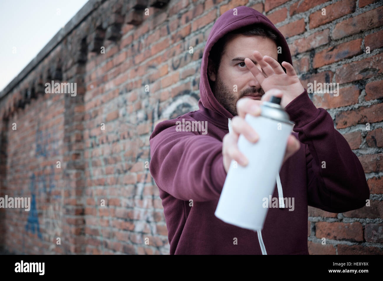 Man writing graffiti on the urban walls Stock Photo - Alamy