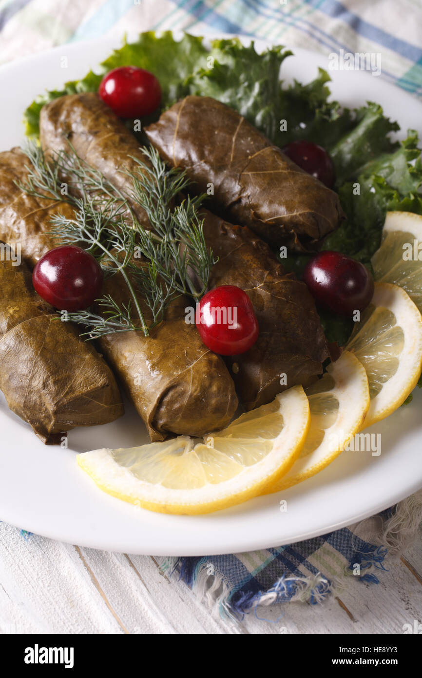 Delicious homemade dolma with lemon and berries on a plate. vertical ...