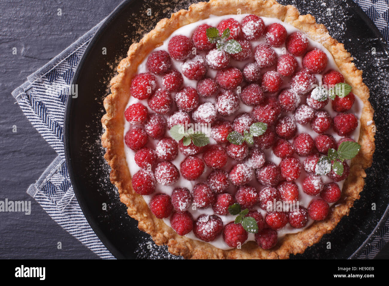 Gourmet raspberry tart with whipped cream on a plate close-up ...