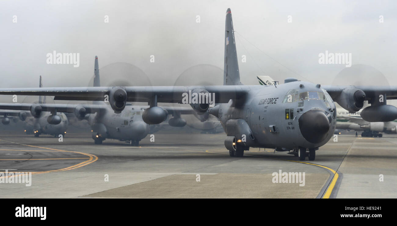 Ten C-130 Hercules aircraft taxi on a runway during a large formation ...