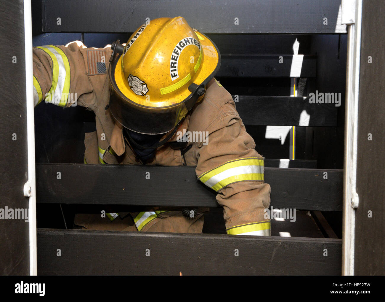 A firefighter weaves through wooden beams during confined space entry ...