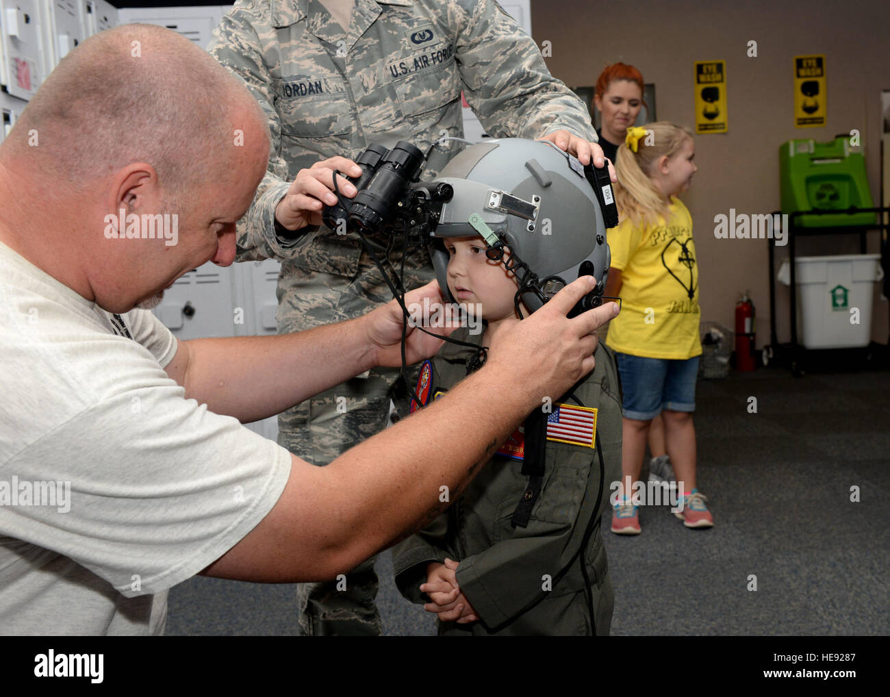 Cody Dugger helps his son, Jaxon, put on a flight helmet equipped with ...