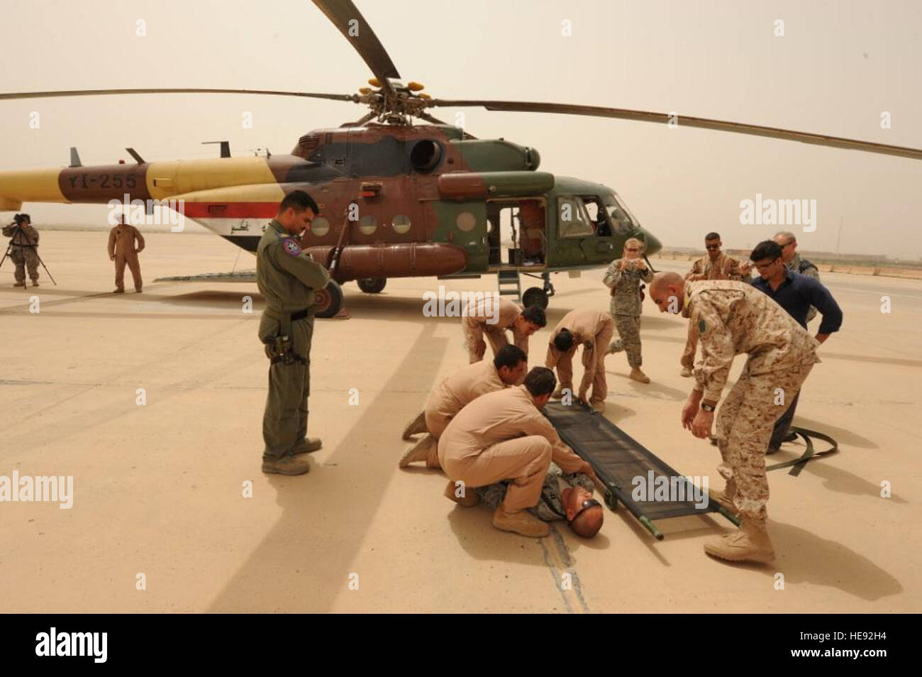Iraqi Security Forces soldiers place an American airman onto a ...