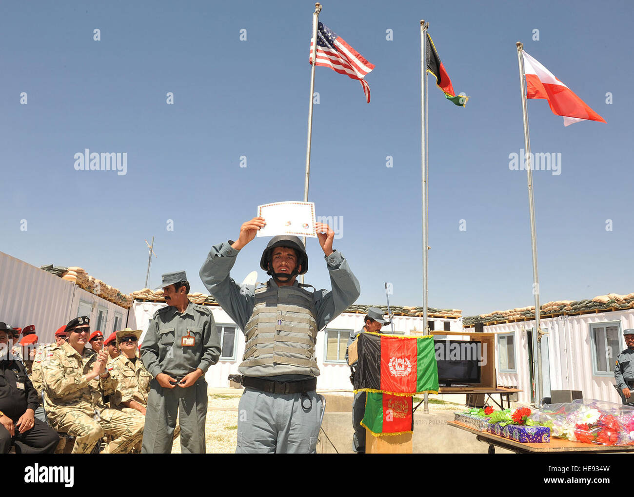 A newly graduated Afghan National Policeman proudly holds his ...