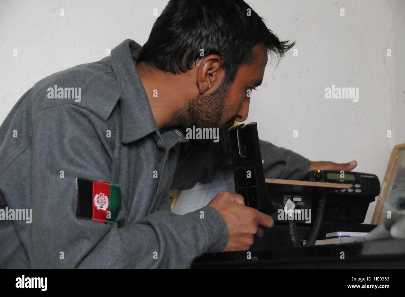 An Afghan national police officer speaks on the radio at ANP ...