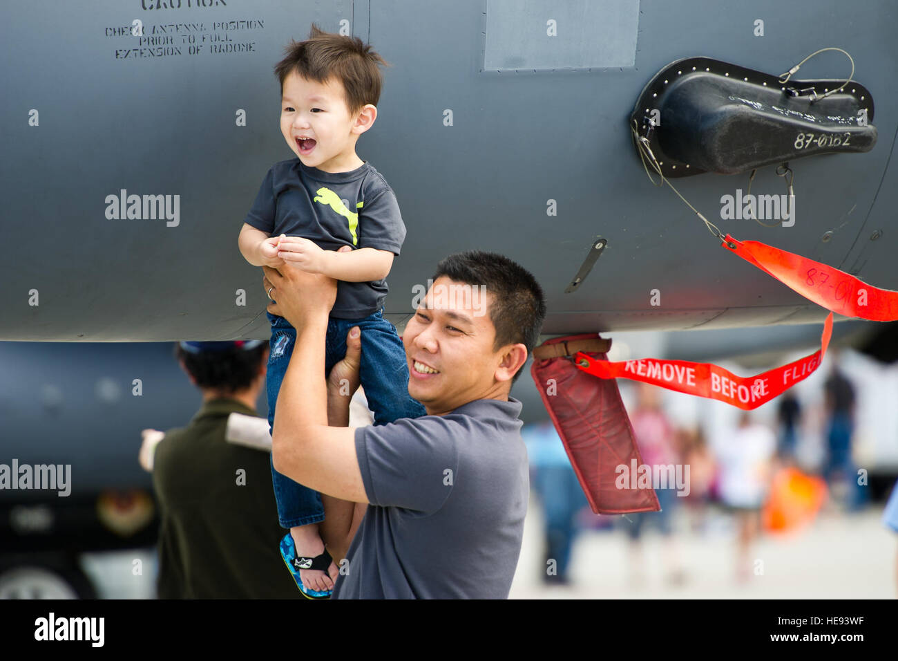 A father holds up his child for a photograph near a static display on ...