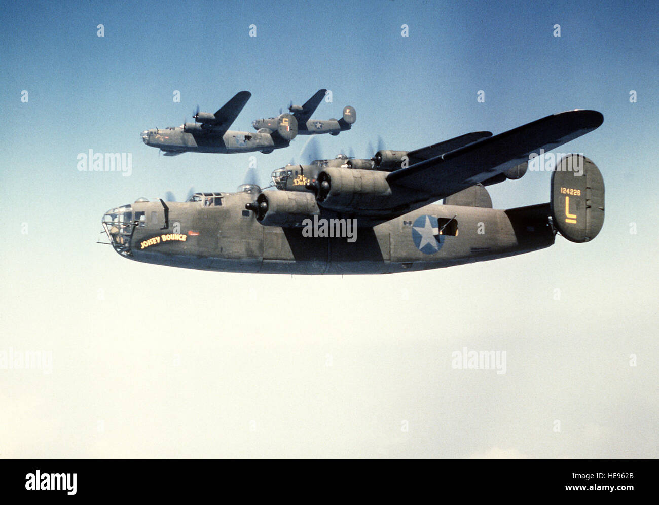 An air-to-air left side view of four B-24 Liberator aircraft in formation. The B-24 was built ...