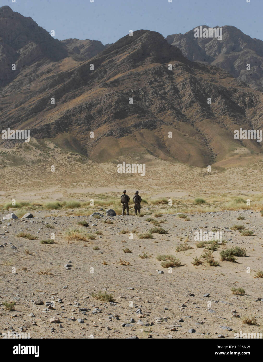 Against the bacdrop of mountains in Afghanistan, two soldiers from ...