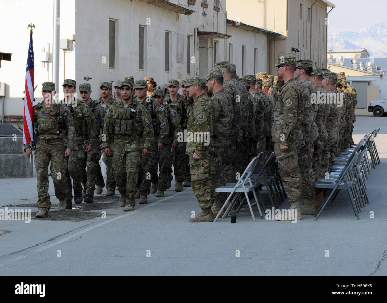 U.S. service members render a salute as a formation of multiservice ...