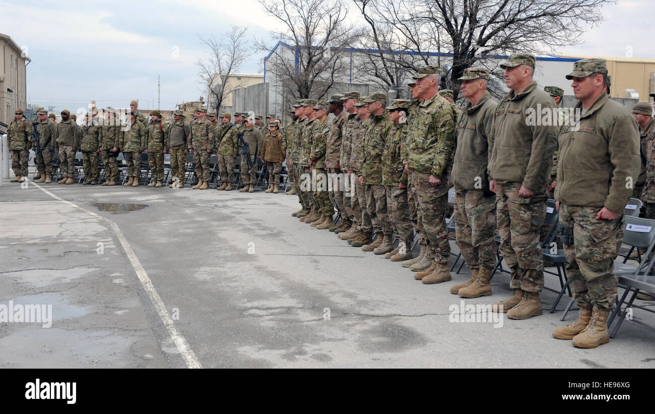 U.S. service members stand at attention during a remembrance ceremony ...