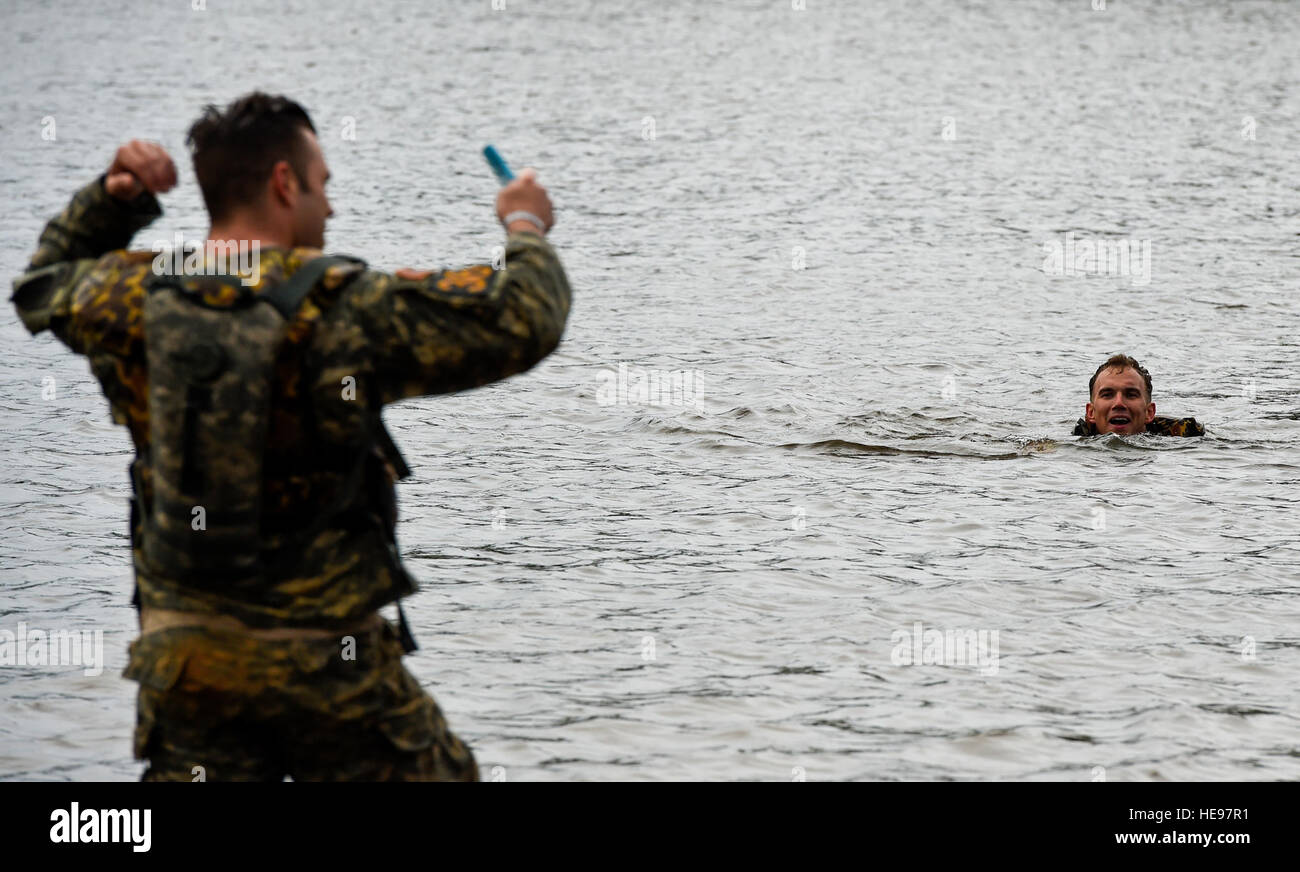U.S. Army Staff Sgt. Ryan Gerber (right) swims toward Staff Sgt ...