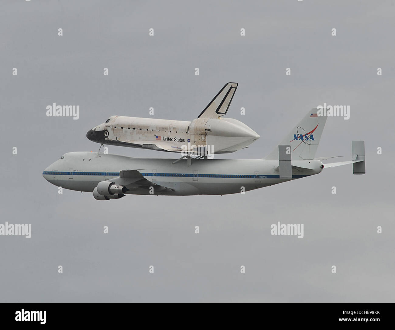 The space shuttle Discovery, atop a modified Boeing 747, flies over ...