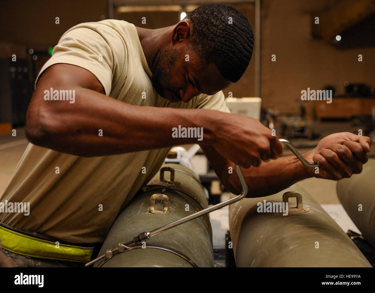 Staff Sgt. Everett Myles uses a speed handle to secure straps on a ...