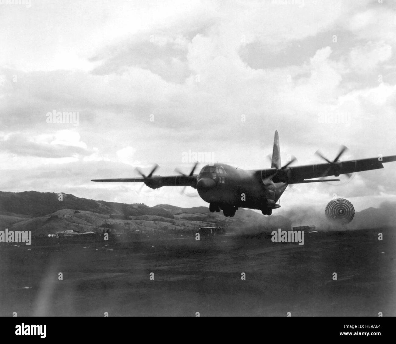 A U.S Air Force C-130B Hercules aircraft passes low over a drop zone in ...