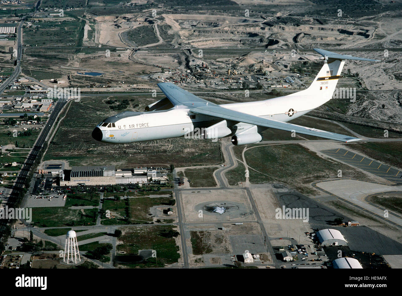 An air-to-air left side view of a C-141B Starlifter aircraft over ...