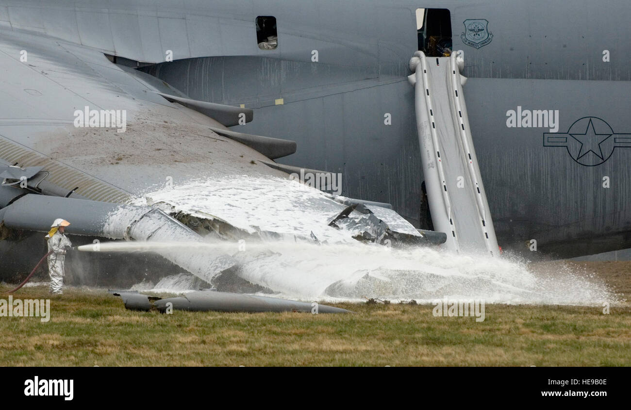 A firefighter hoses down the crash site of a C-5 Galaxy. The aircraft ...