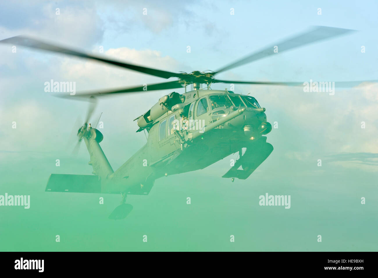 A U.S. Air Force HH-60G Pave Hawk helicopter hovers as aircrew members ...