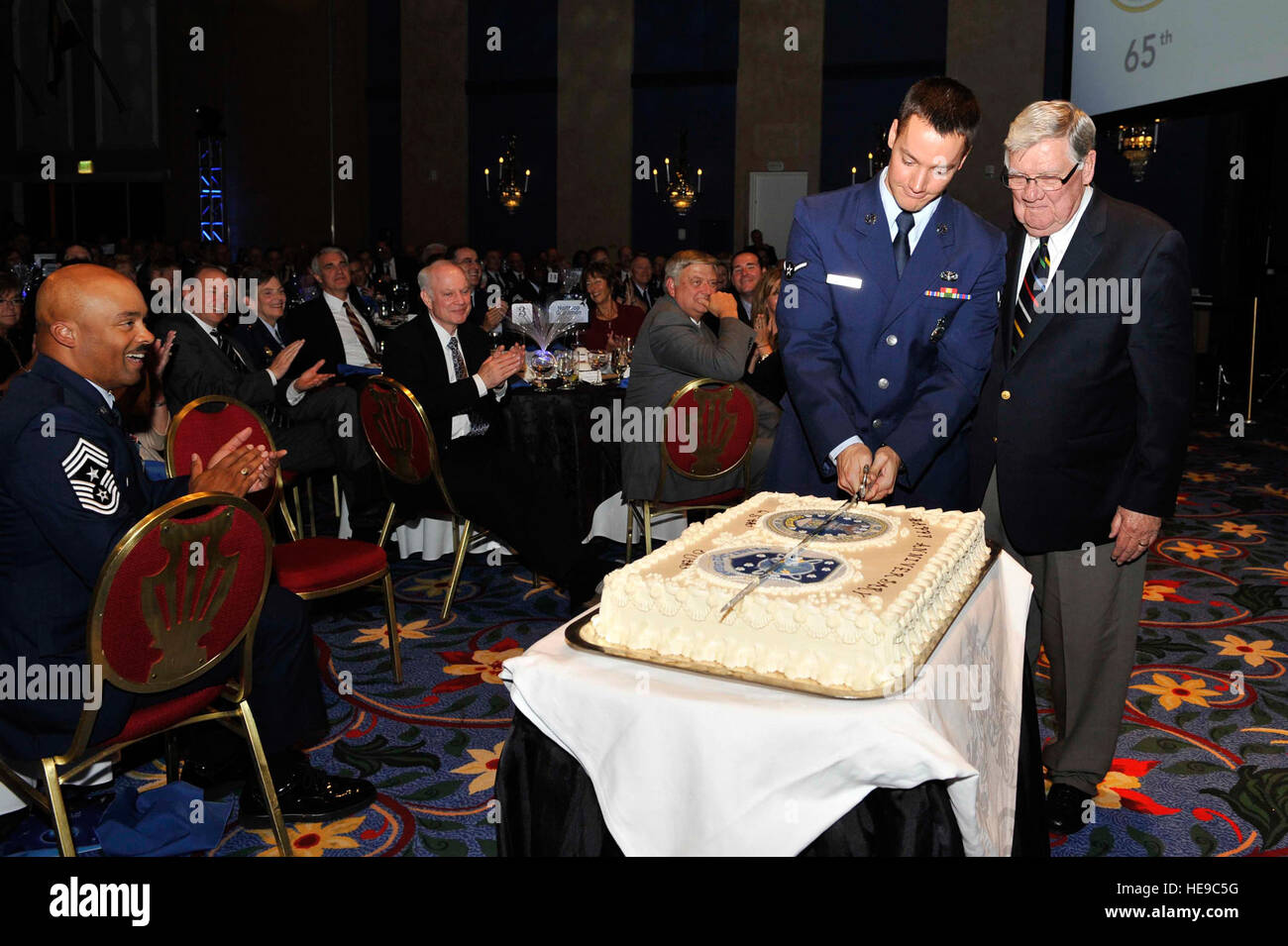 Retired Maj. Gen. Tim Padden and Airman Samuel Macklin, cut the ...