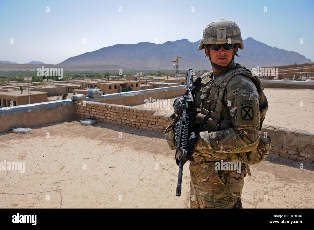 U.S. Army Sgt. Adam Critz provides overwatch security from the roof of ...