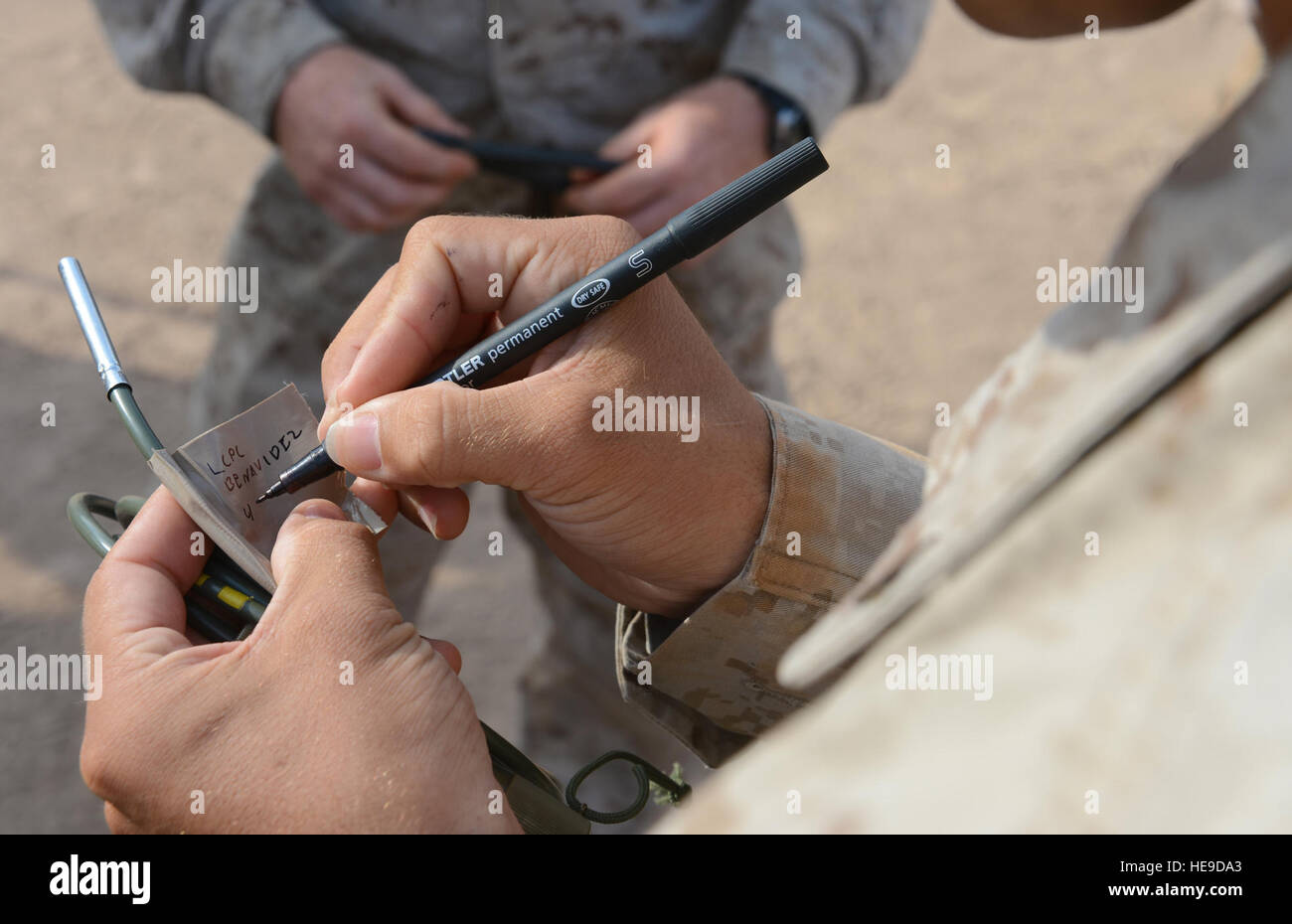 A U.S. Marine labels each improvised charge with a net explosive weight ...