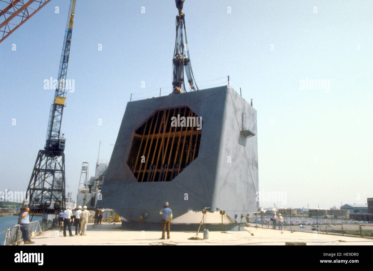 Workers make final adjustments as the radar turret is lowered onto the ...