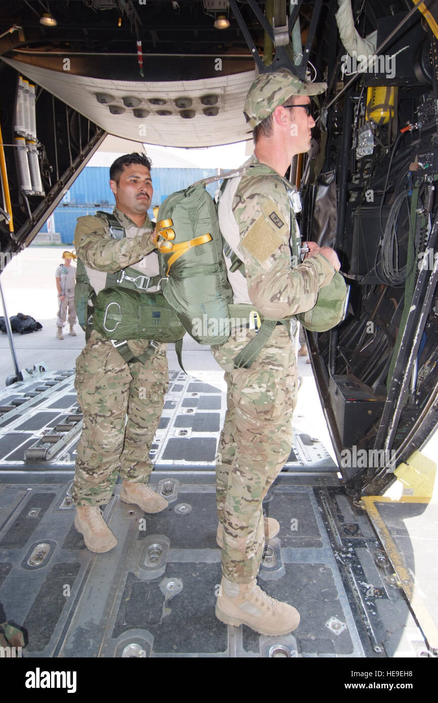 TSgt Joe Robles performs a safety check of a parachute on TSgt Sean ...