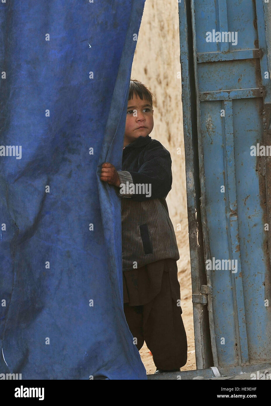 An Afghan boy watches as U.S. Soldiers conduct a combat reconnaissance ...