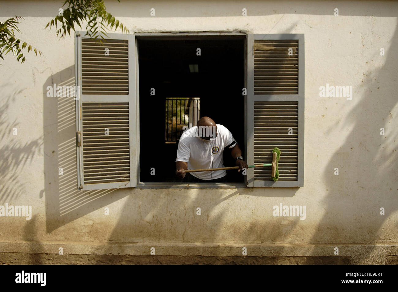 Storekeeper 1st Class Carl Hunt brushes off the dirt from a classroom ...
