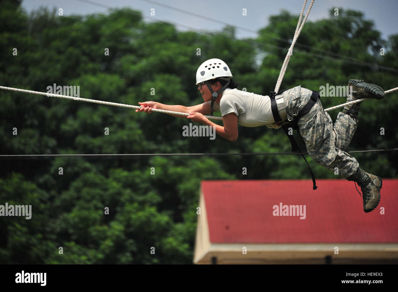 A Commissioned Officer Training School student pulls herself across a ...
