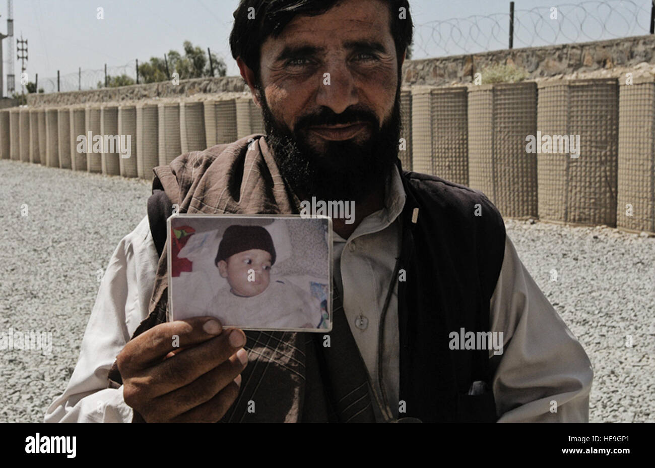 Afghan citizen Noor Ahmad shows a laminated picture of his son, Samir ...