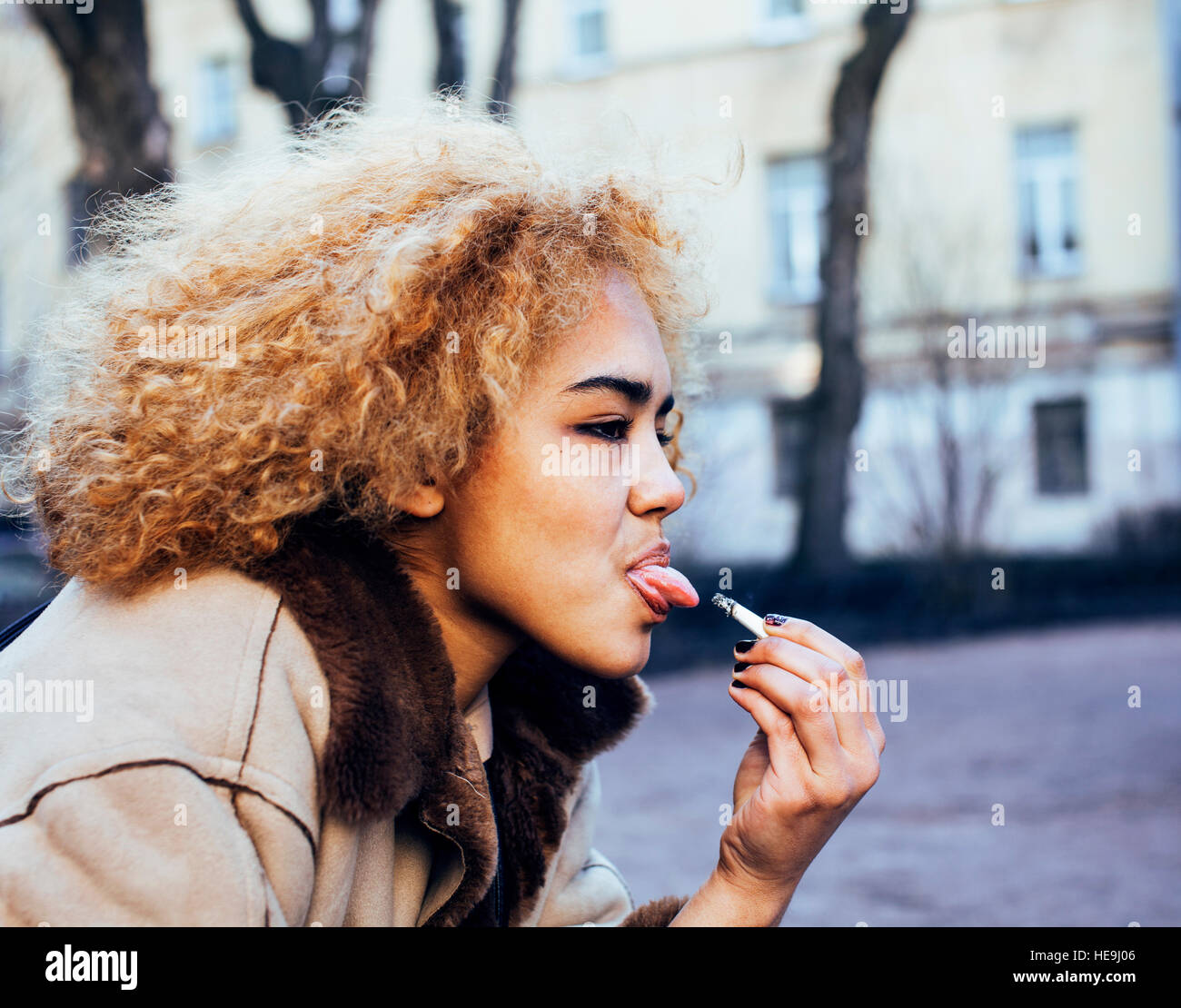 young pretty girl teenage outside smoking cigarette, looking like real junky, social issues ...