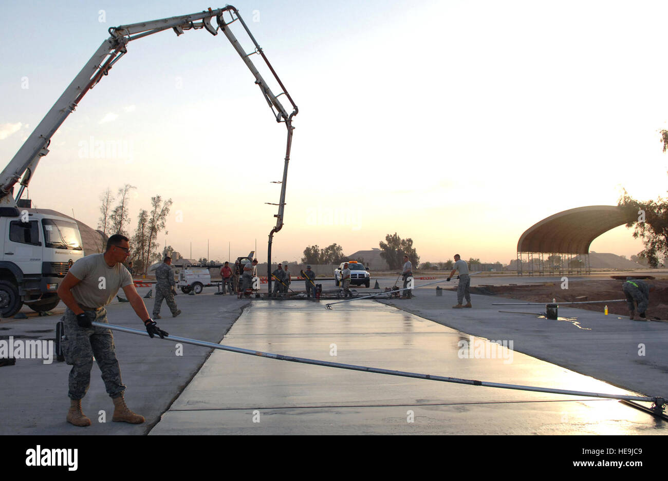 Tech. Sgt. Adam Brothers smoothes out a freshly poured concrete pad May ...