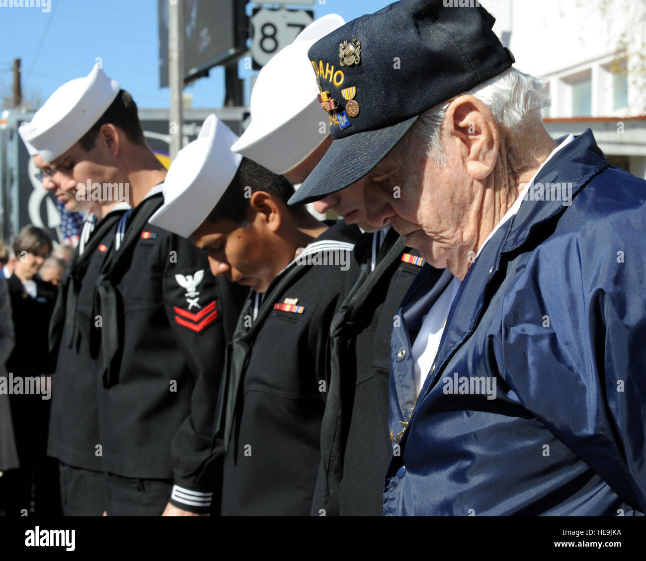 World War II veterans and U.S. Navy sailors bow during a prayer at the ...