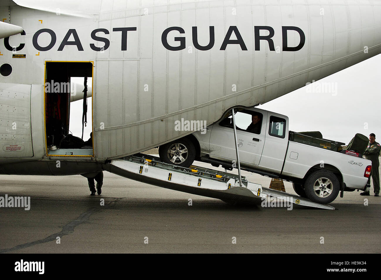 U.S. Coast Guardsmen offload a government vehicle from HC-130H Hercules ...