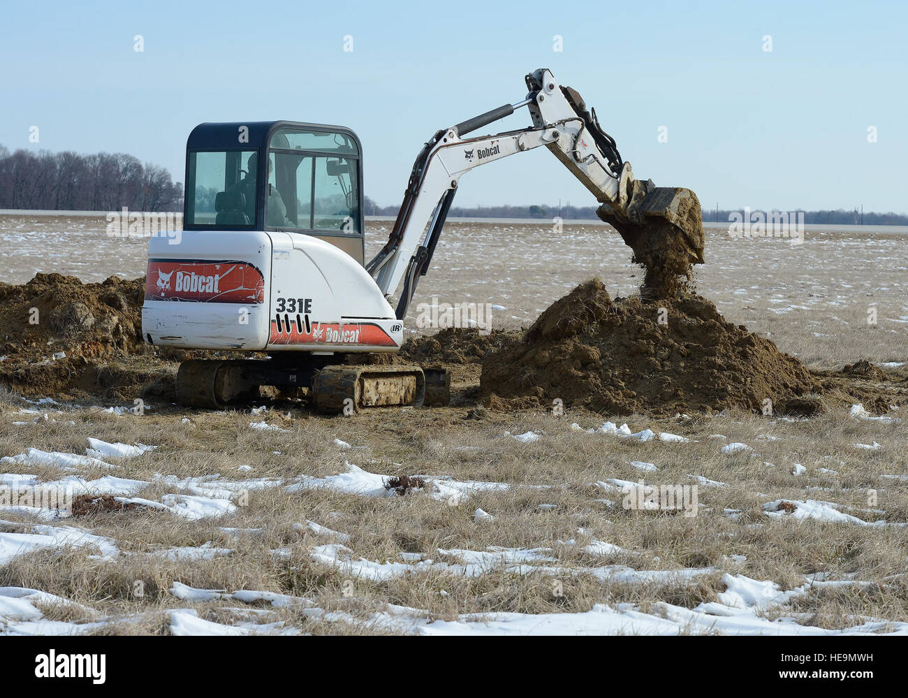 A Bobcat 331E mini-excavator digs up part of a water line near the ...