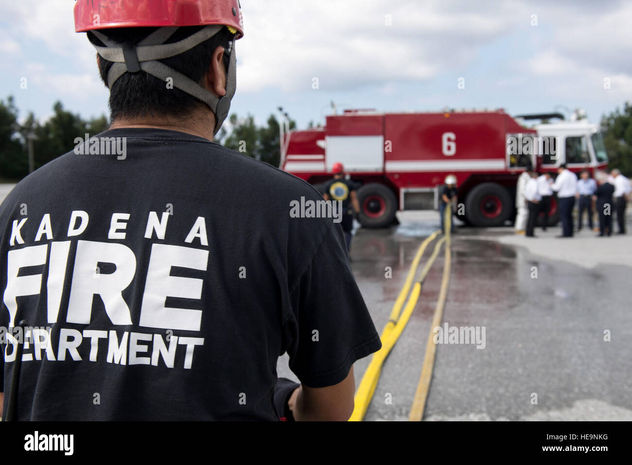 Firefighters from the Kadena Fire Department wring out a fire hose ...